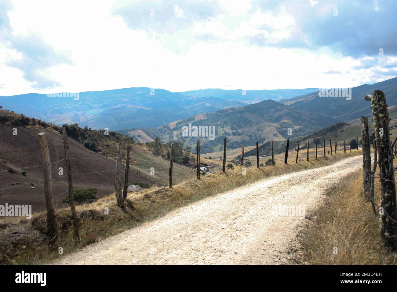 Sand Road in rural zone with colombian mountains landscape and blue sky ...