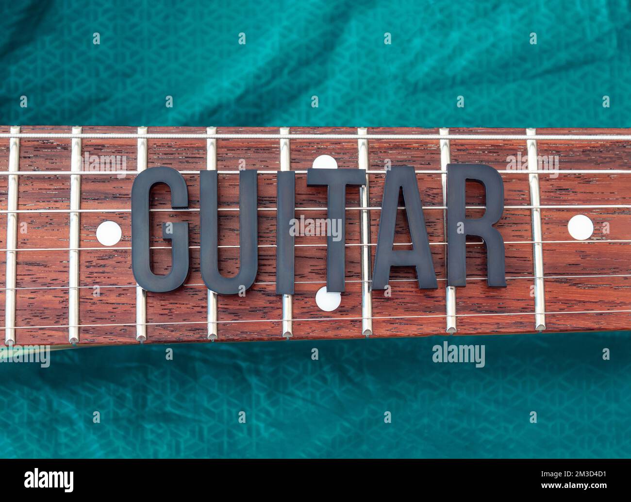 Closeup to a GUITAR lettering black word over a six electric guitar ...