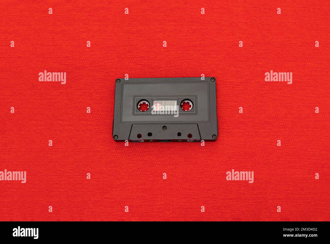 Top View of an old black cassette over a red cloth. Fashion and retro ...