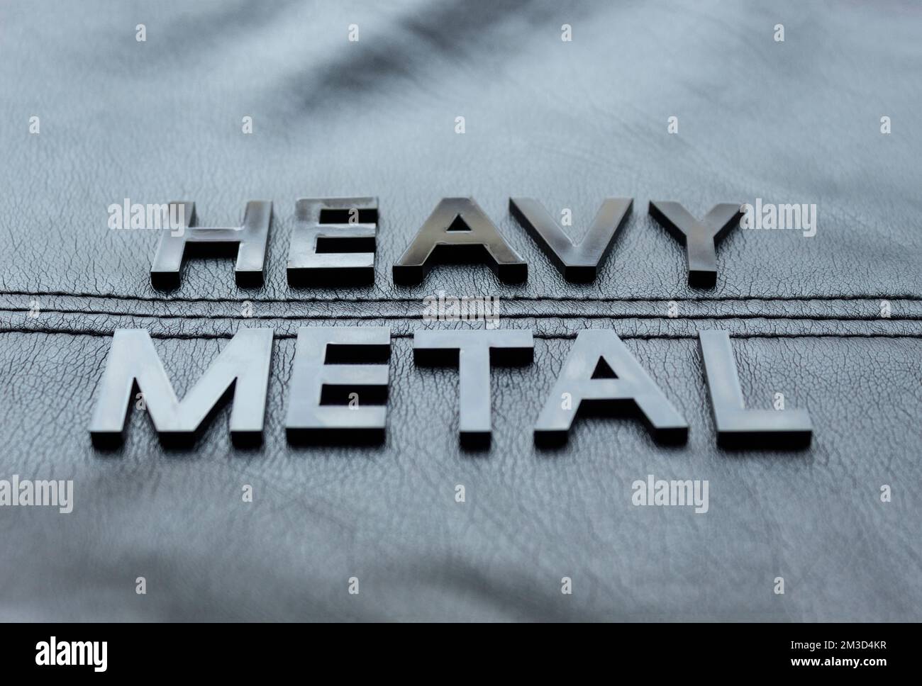 Closeup to a HEAVY METAL black lettering word over a black leather ...