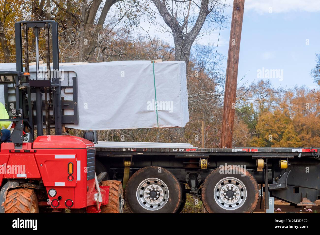 Forklifts are used to unload parts of construction materials from truck ...