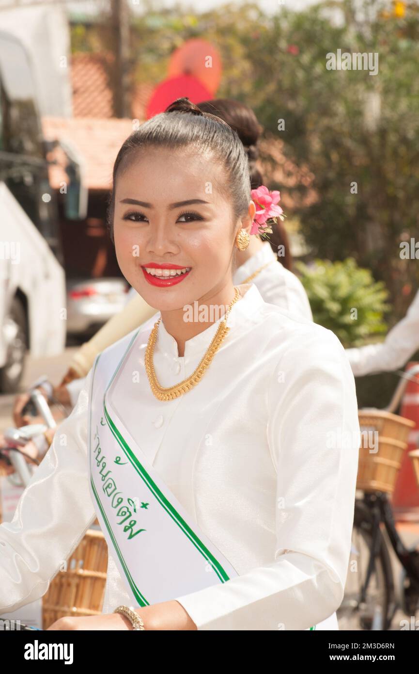Pretty women in traditional costume hold umbrella and ride bicycle parade show in 33rd ...