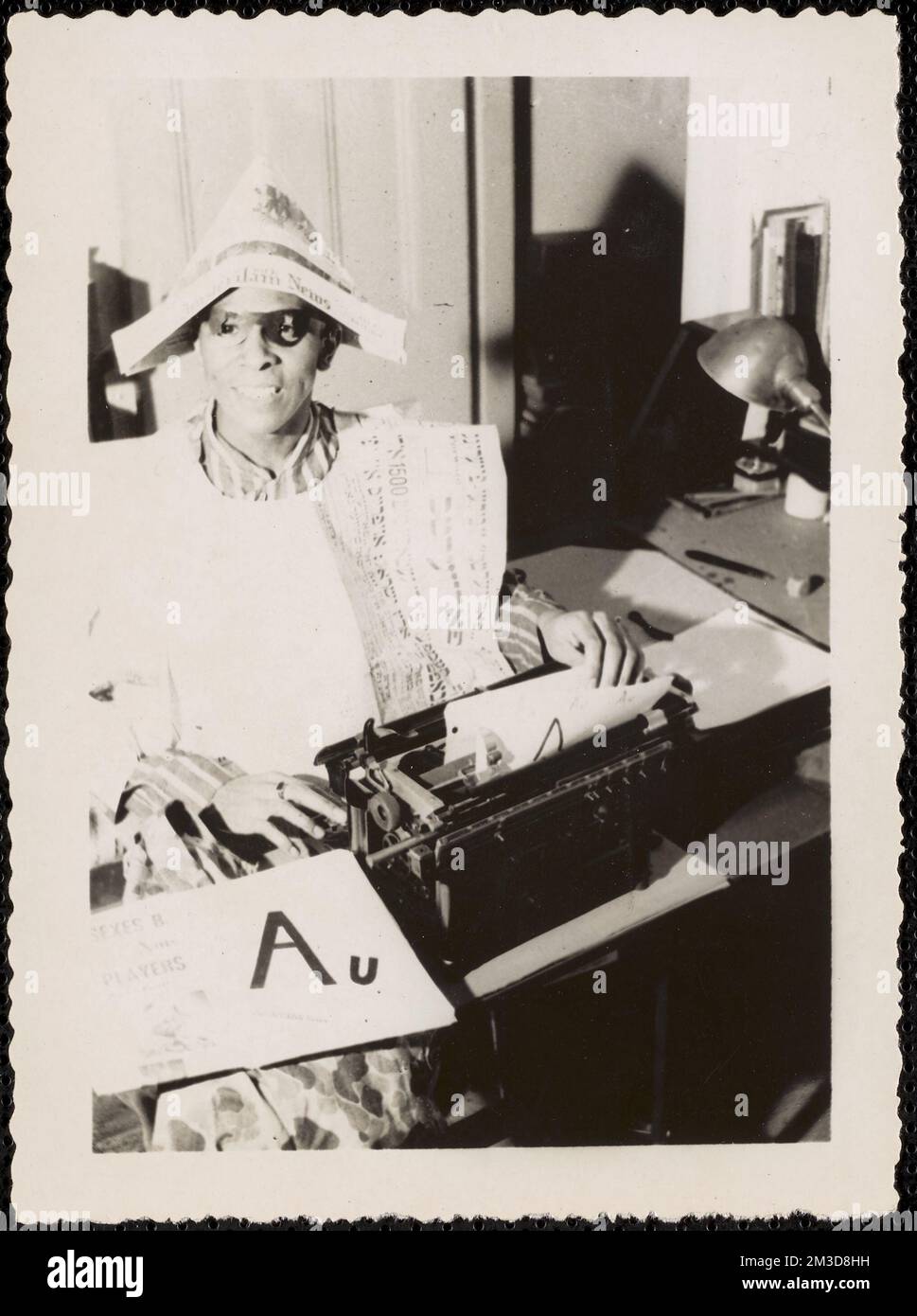 Jack Miller sits at typewriter wearing costume made of newspaper ...