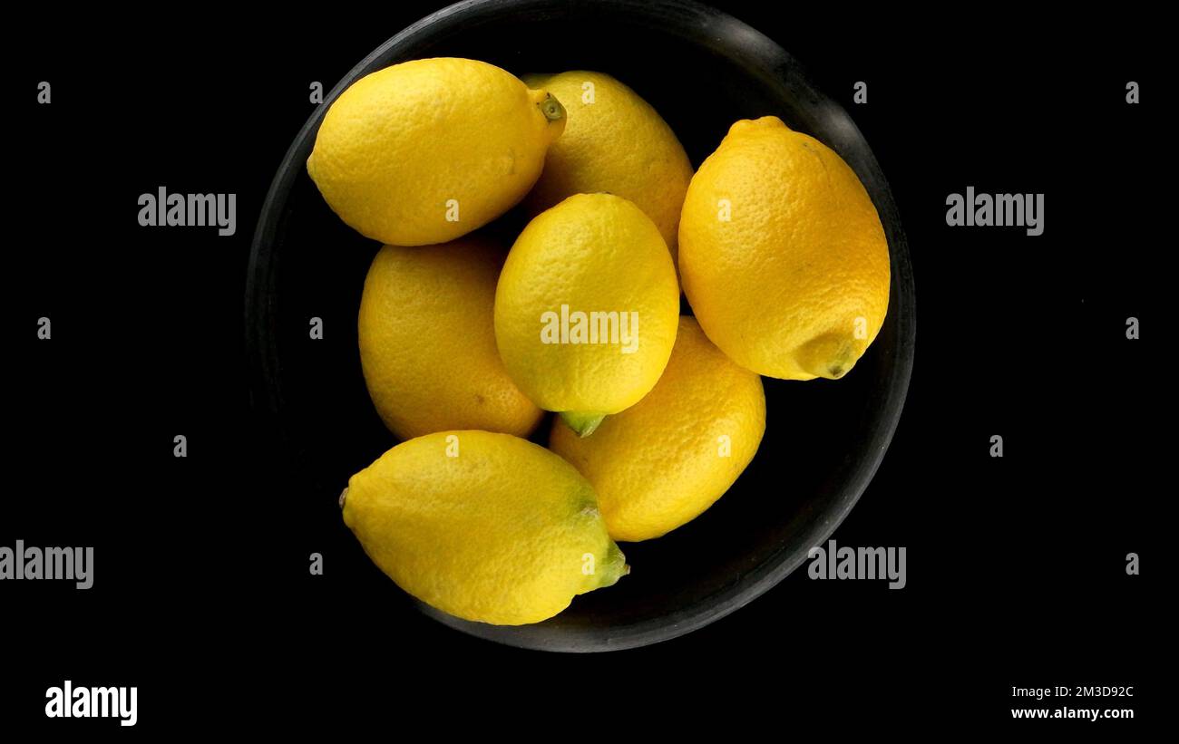 Whole lemons rotating on black background Stock Photo - Alamy