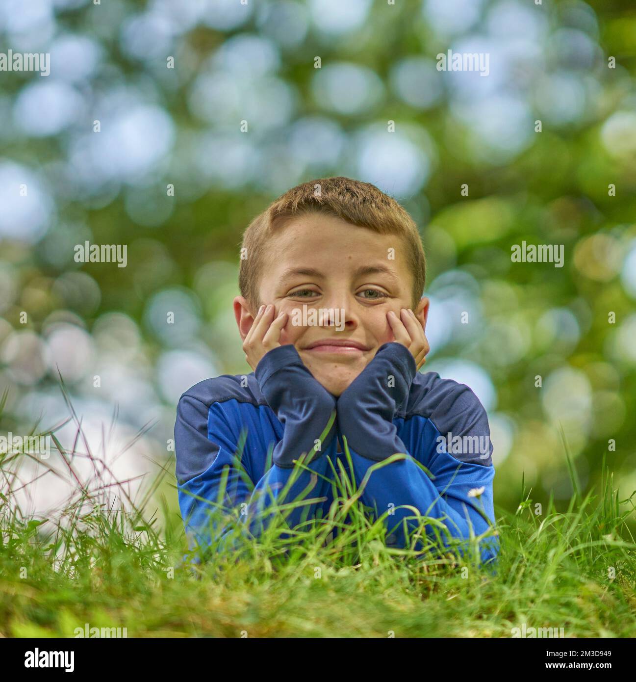 A portrait of a young happy boy in a green park, in deep thought Stock ...