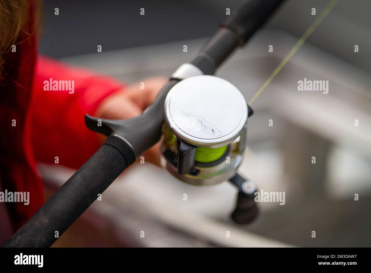 girl in a dinghy fishing with a fishing rod while camping in america ...