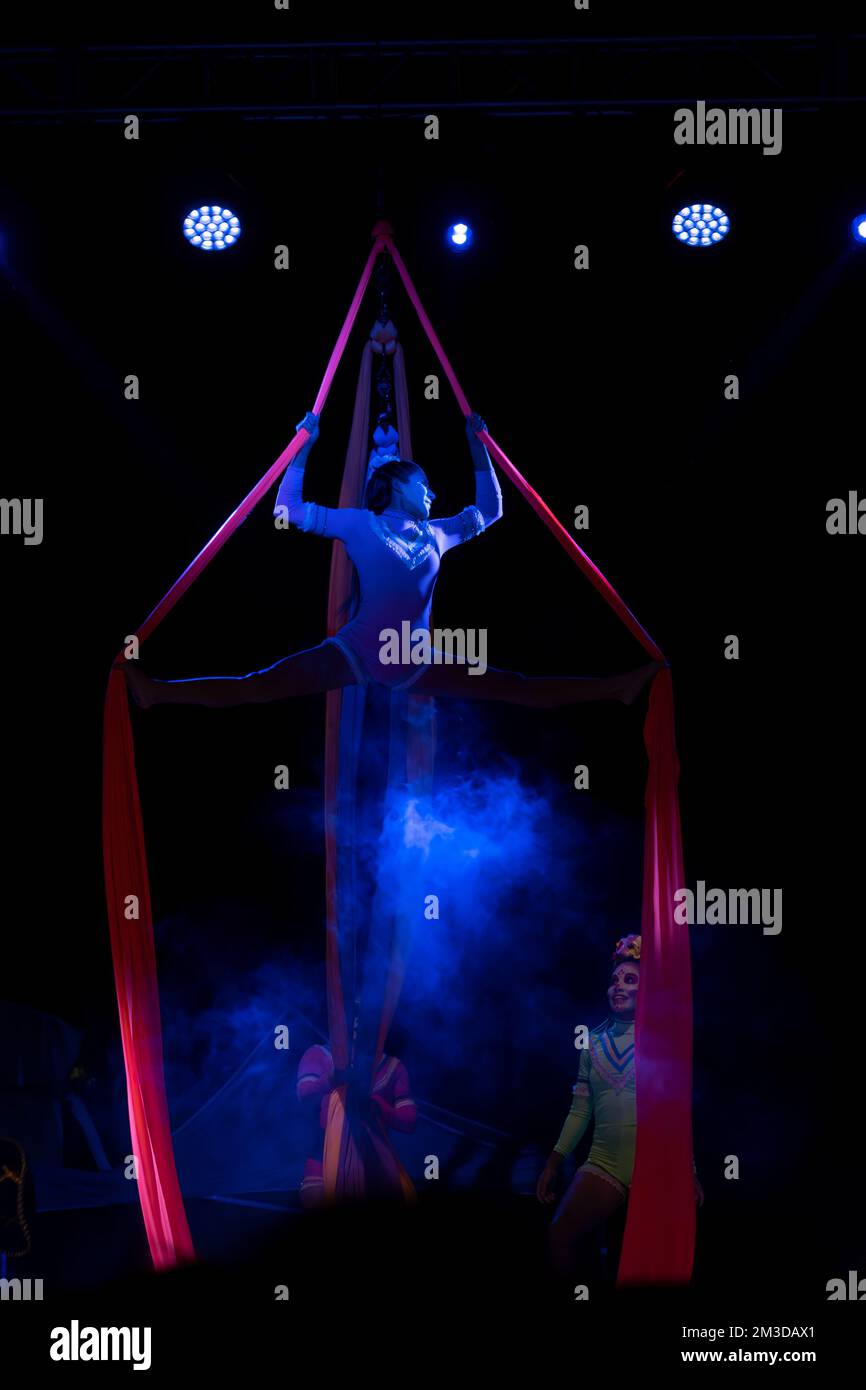 young women dancing in the air with fabrics, night lights, smoke ...