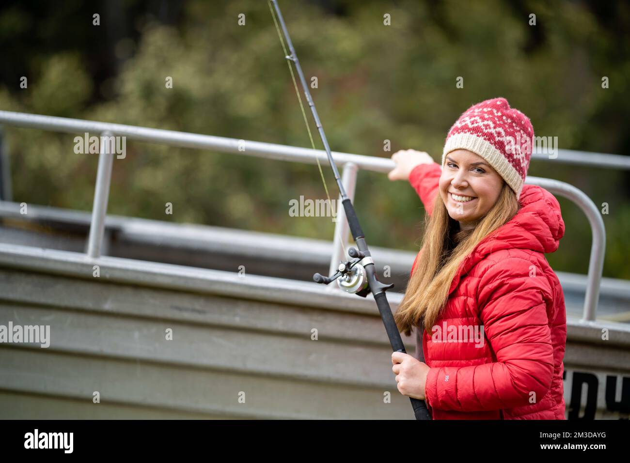 girl in a dinghy fishing with a fishing rod while camping in america ...