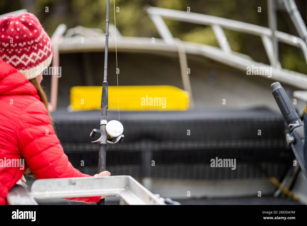 girl in a dinghy fishing with a fishing rod while camping in america ...