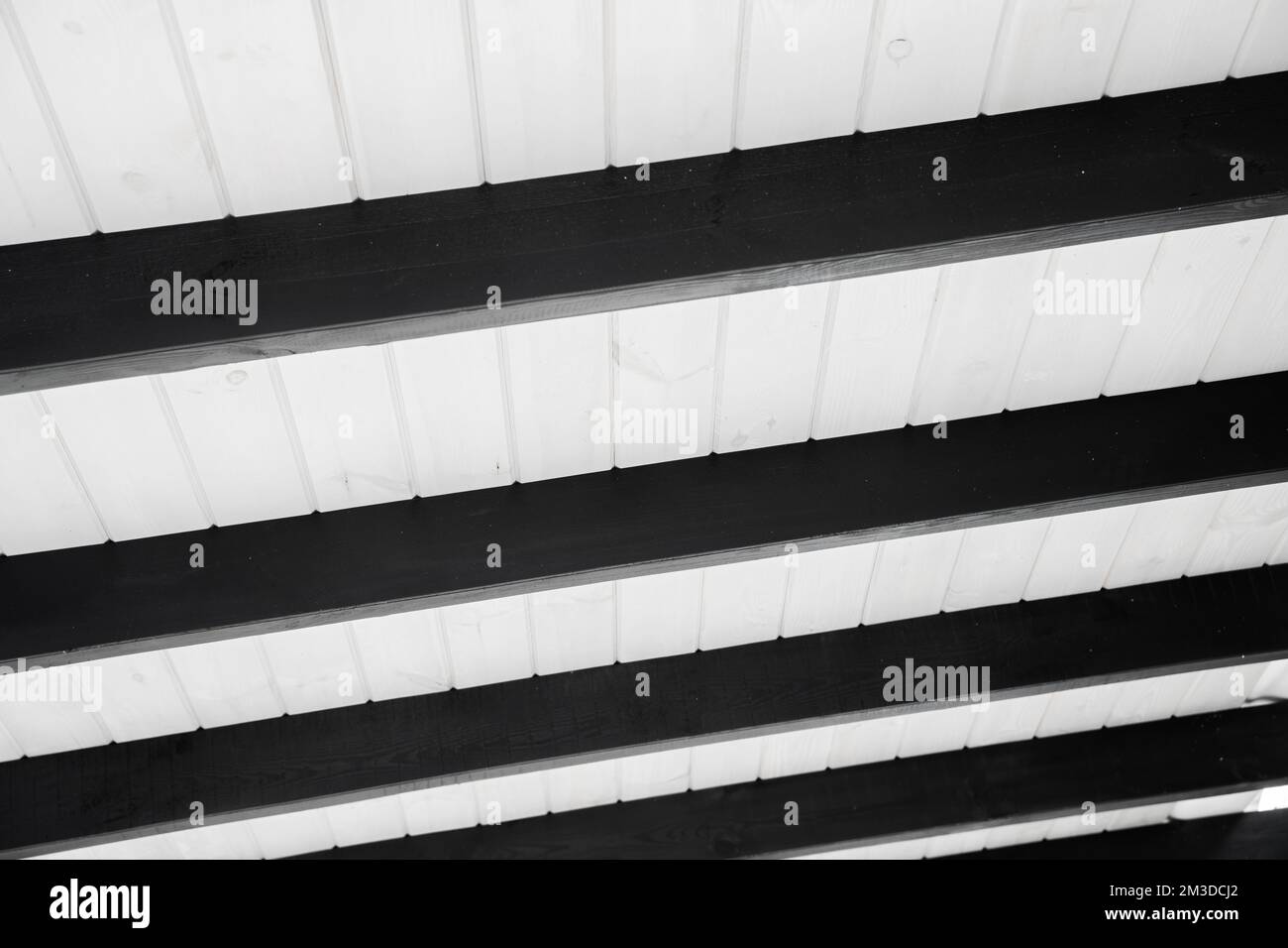 Terrace made of wood with white lining and black rafters. Stylish ...