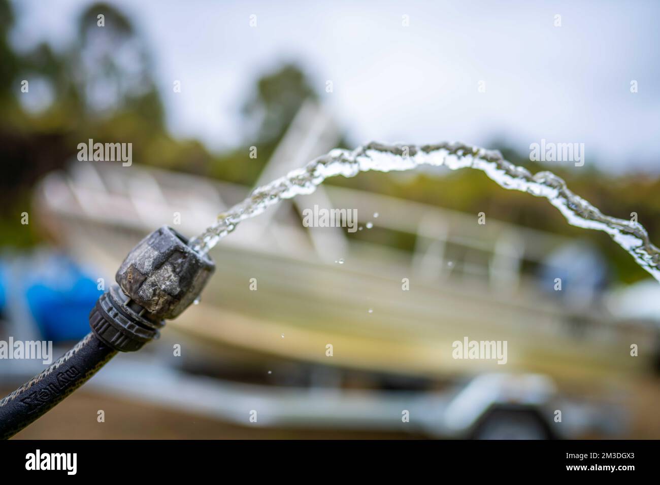 filling up water tank of caravan while camping. washing car and boat in ...