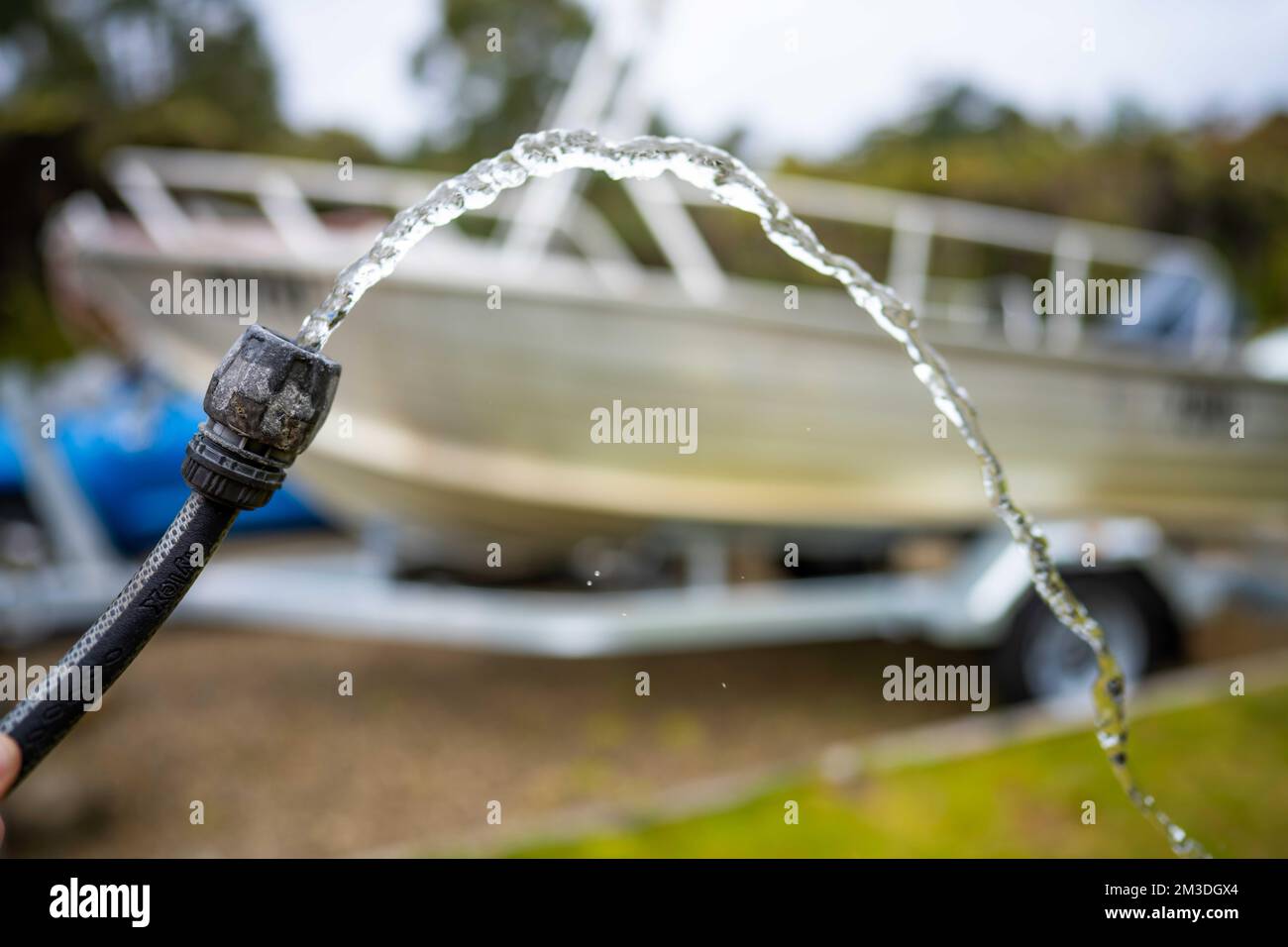 filling up water tank of caravan while camping. washing car and boat in ...