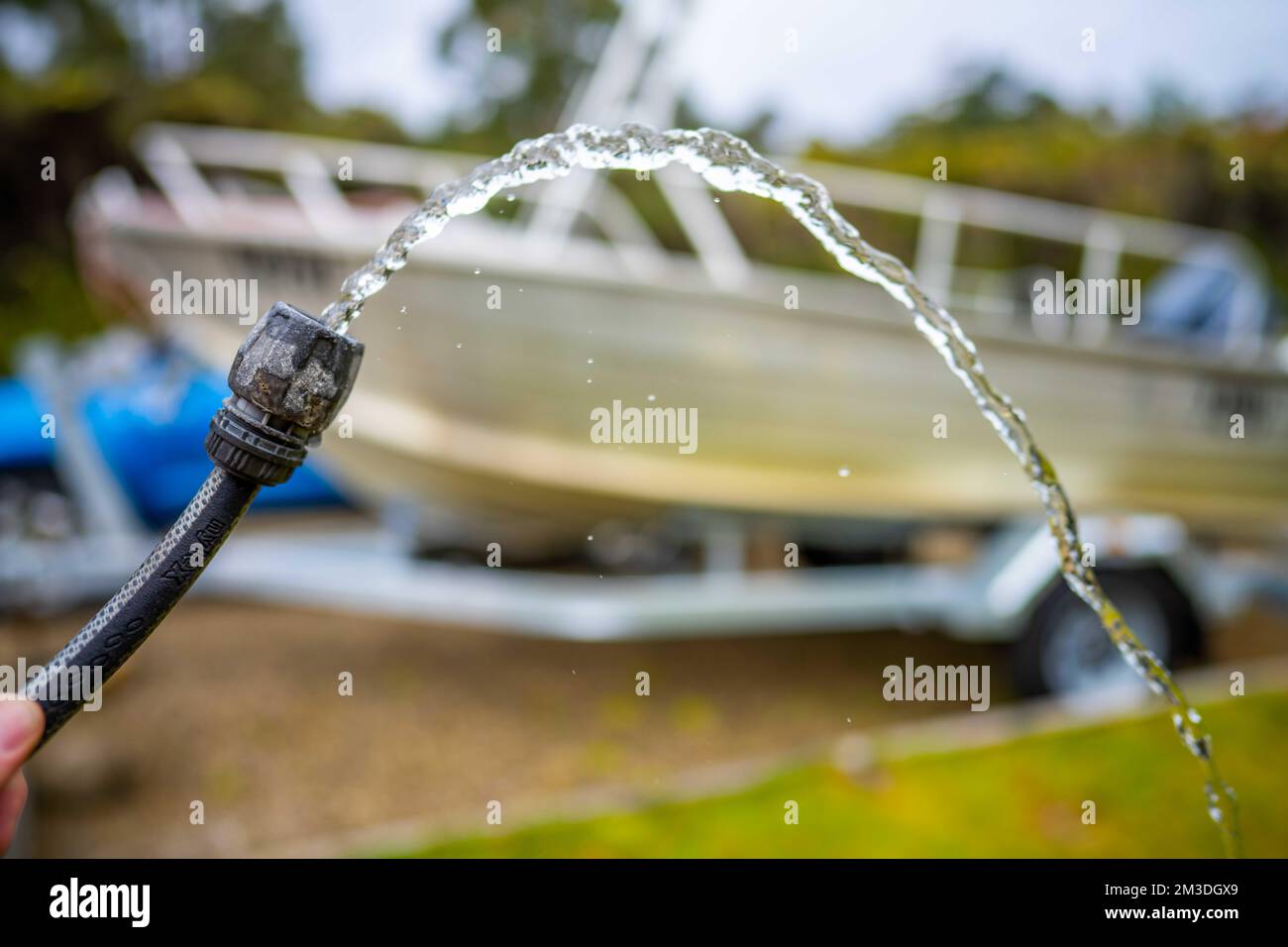 filling up water tank of caravan while camping. washing car and boat in ...