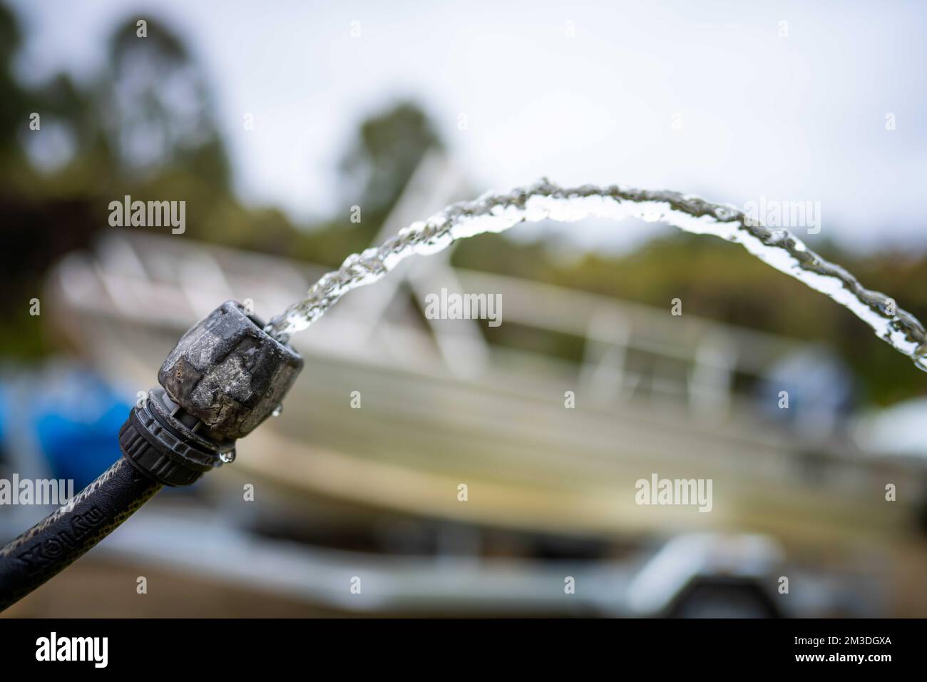filling up water tank of caravan while camping. washing car and boat in ...