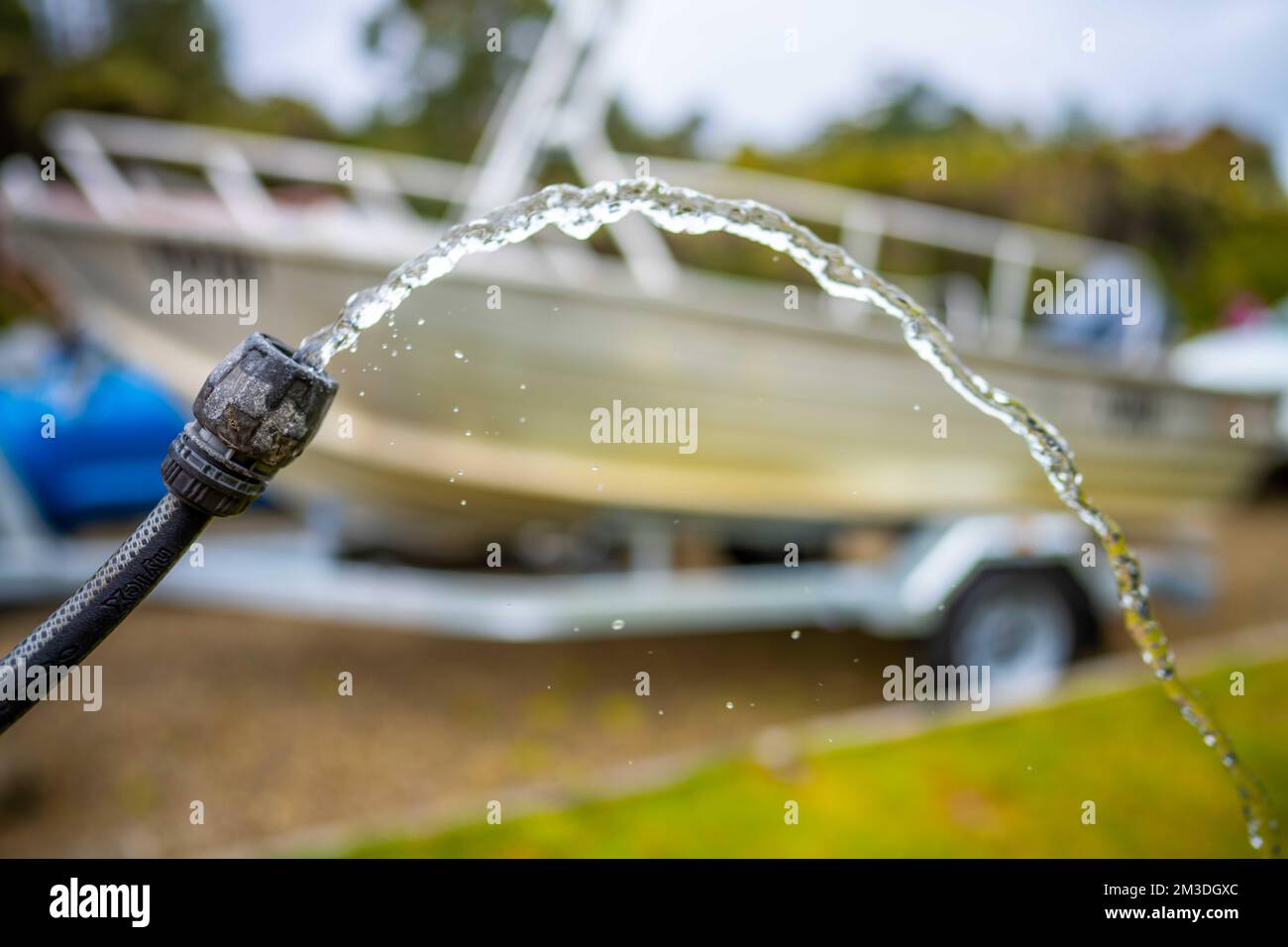 filling up water tank of caravan while camping. washing car and boat in ...
