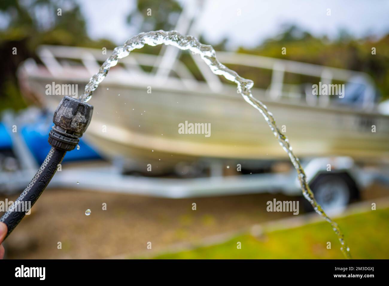 filling up water tank of caravan while camping. washing car and boat in ...