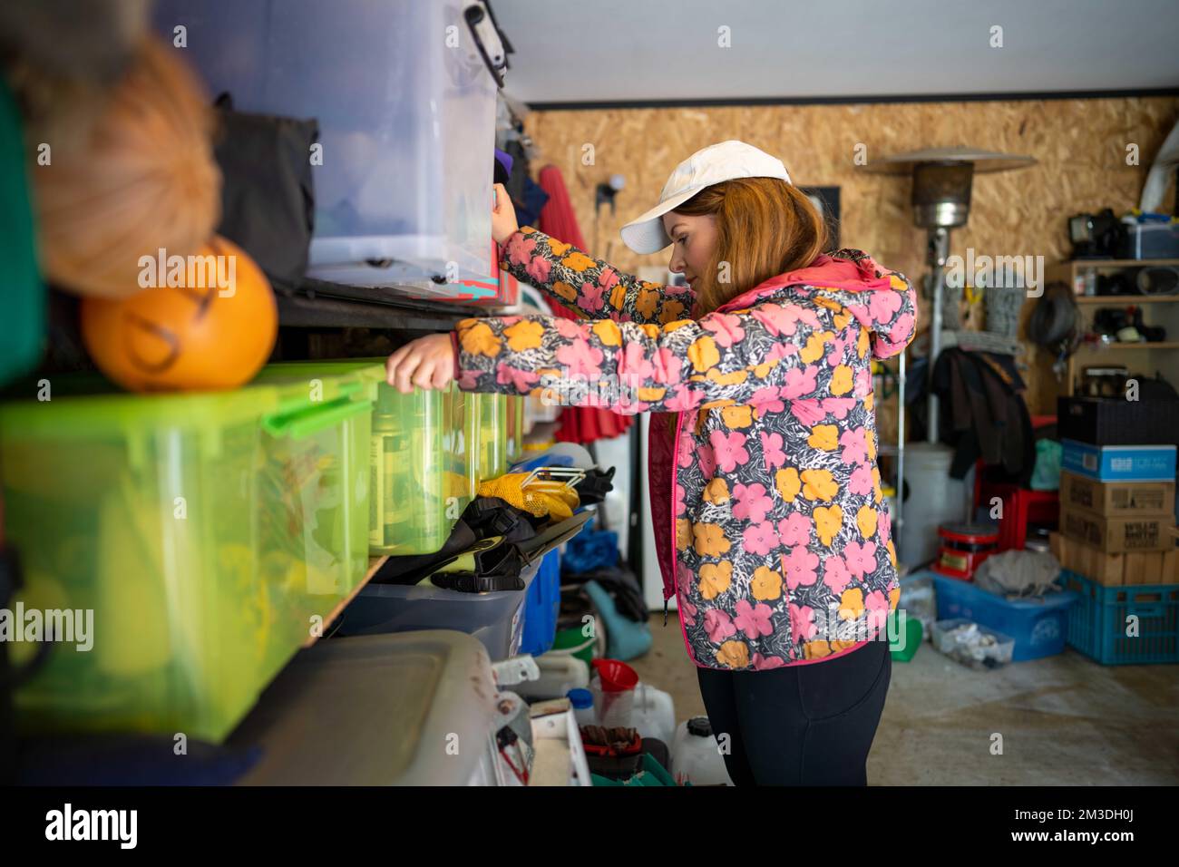 gril packing up a shed in storage containers. woman packing for camping ...