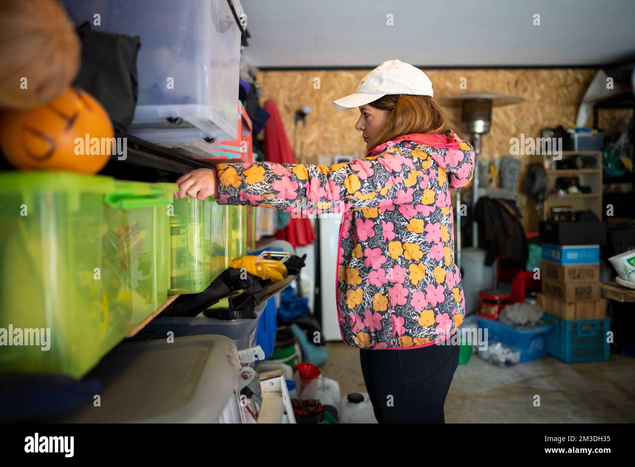 gril packing up a shed in storage containers. woman packing for camping ...