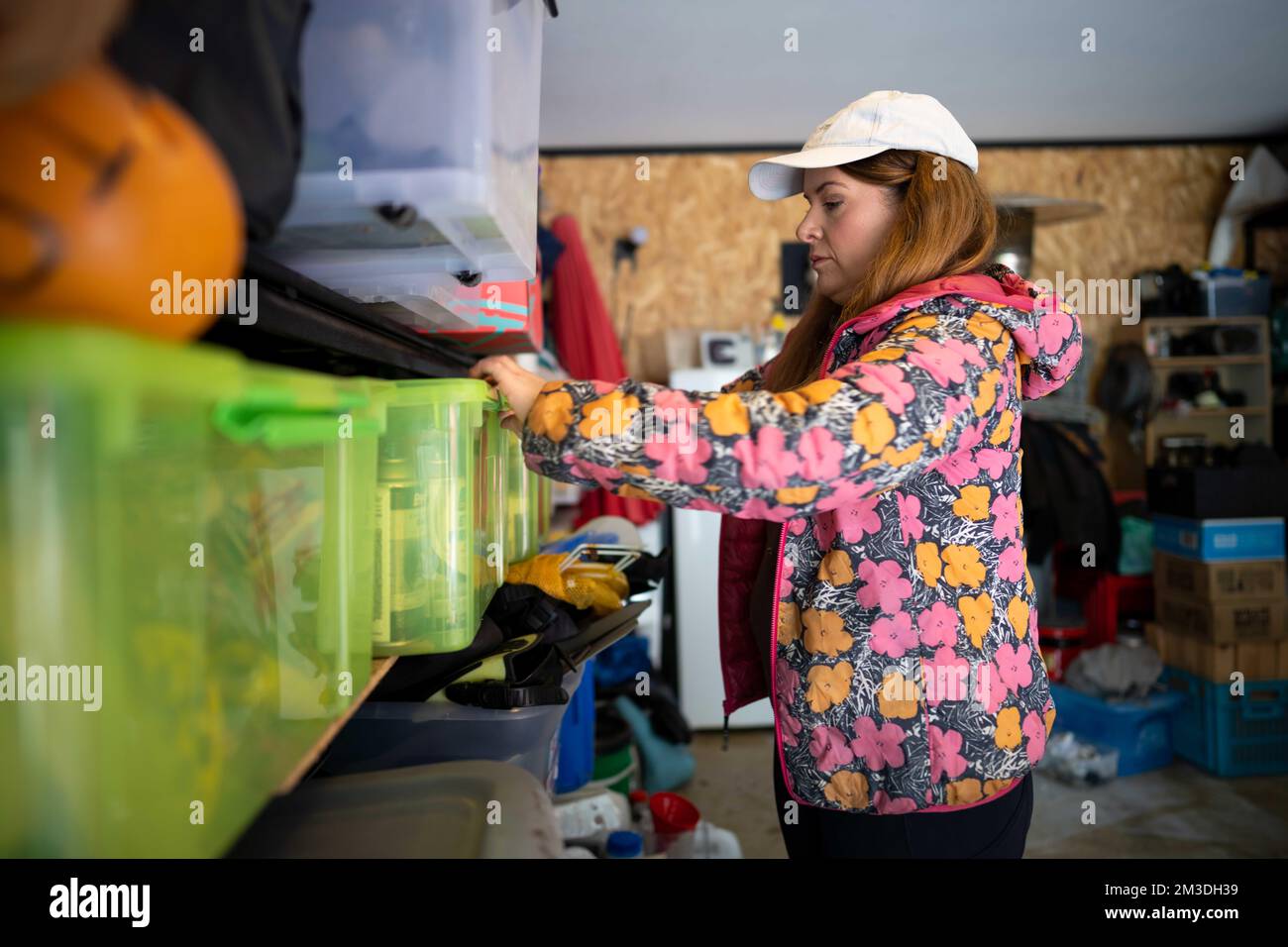 gril packing up a shed in storage containers. woman packing for camping ...