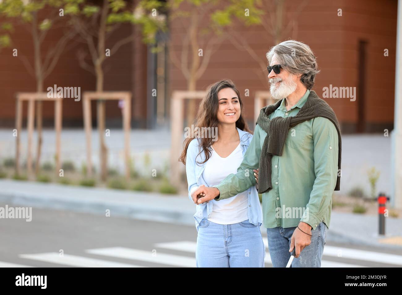 Helping elderly cross street hi-res stock photography and images - Alamy