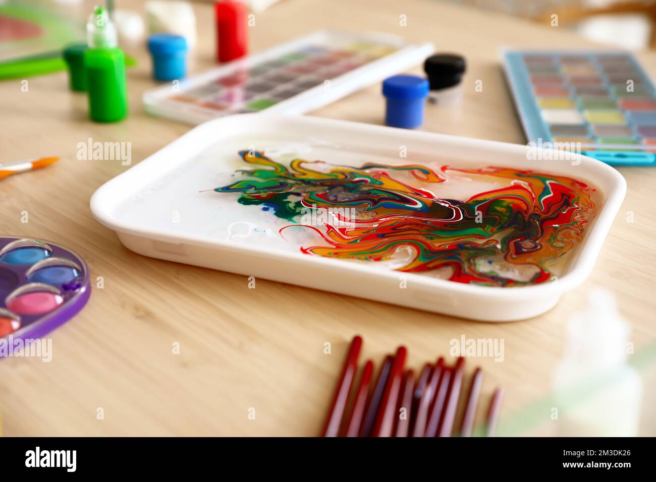 Container with water and paints for Ebru on table in workshop, closeup ...