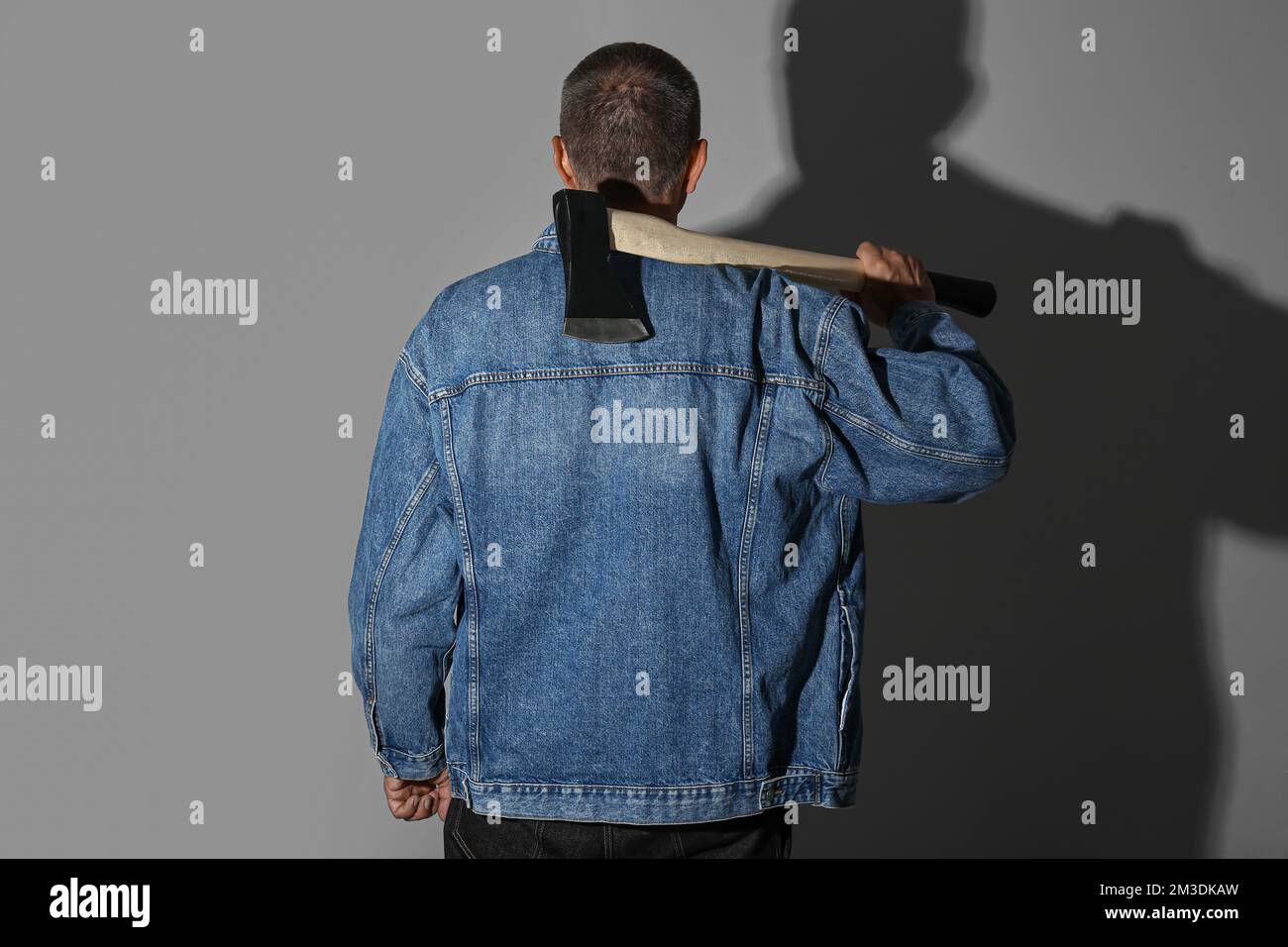 Man with ax on grey background, back view Stock Photo - Alamy