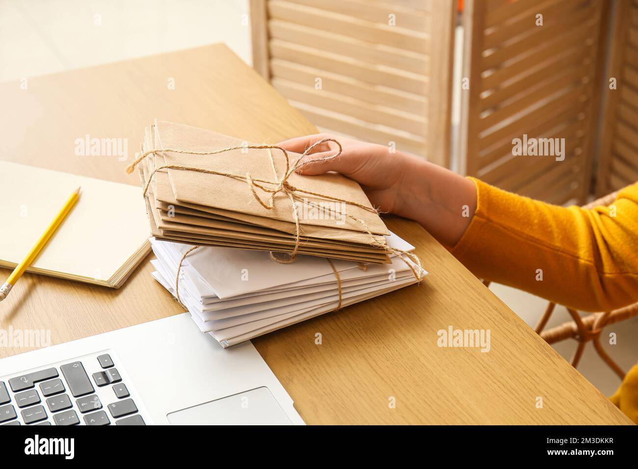 Woman holding stack of tied letters on wooden table. Mail concept Stock ...