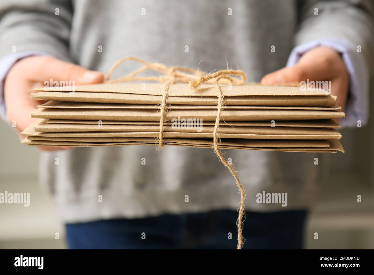 Woman holding stack of tied letters, closeup. Mail concept Stock Photo ...