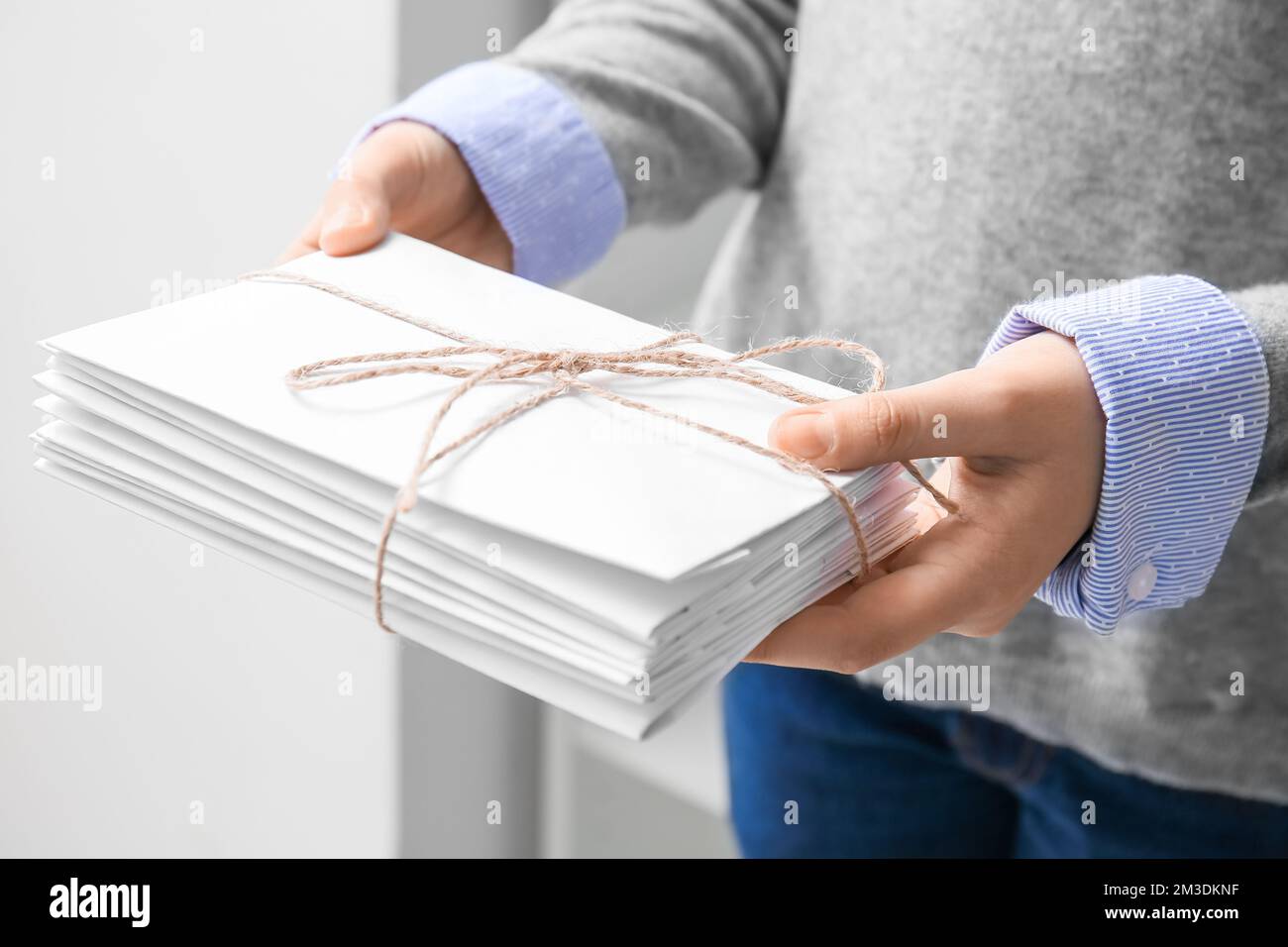 Woman holding tied letters, closeup. Mail concept Stock Photo - Alamy