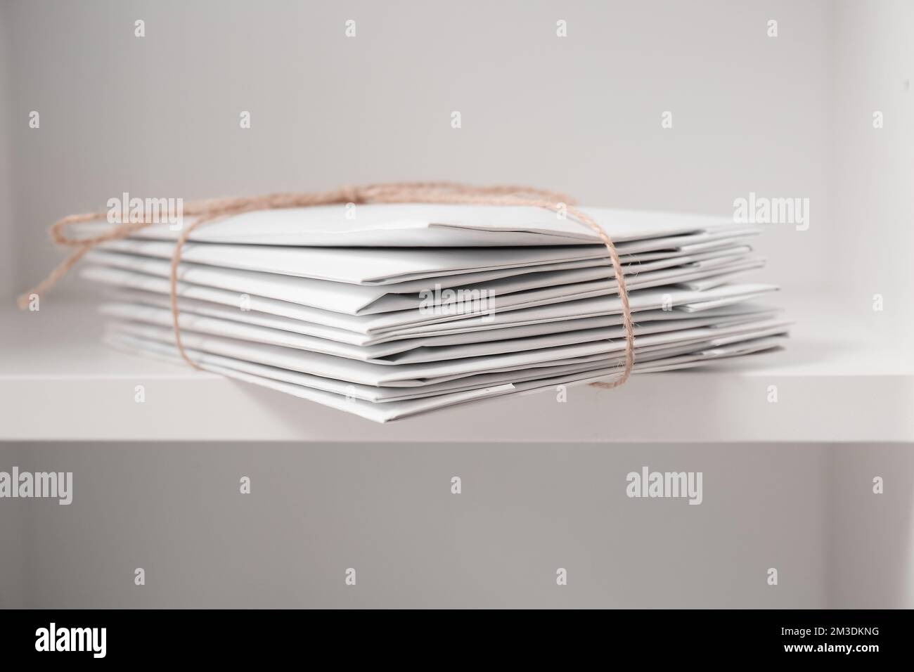 Stack of tied letters on shelf, closeup. Mail concept Stock Photo - Alamy