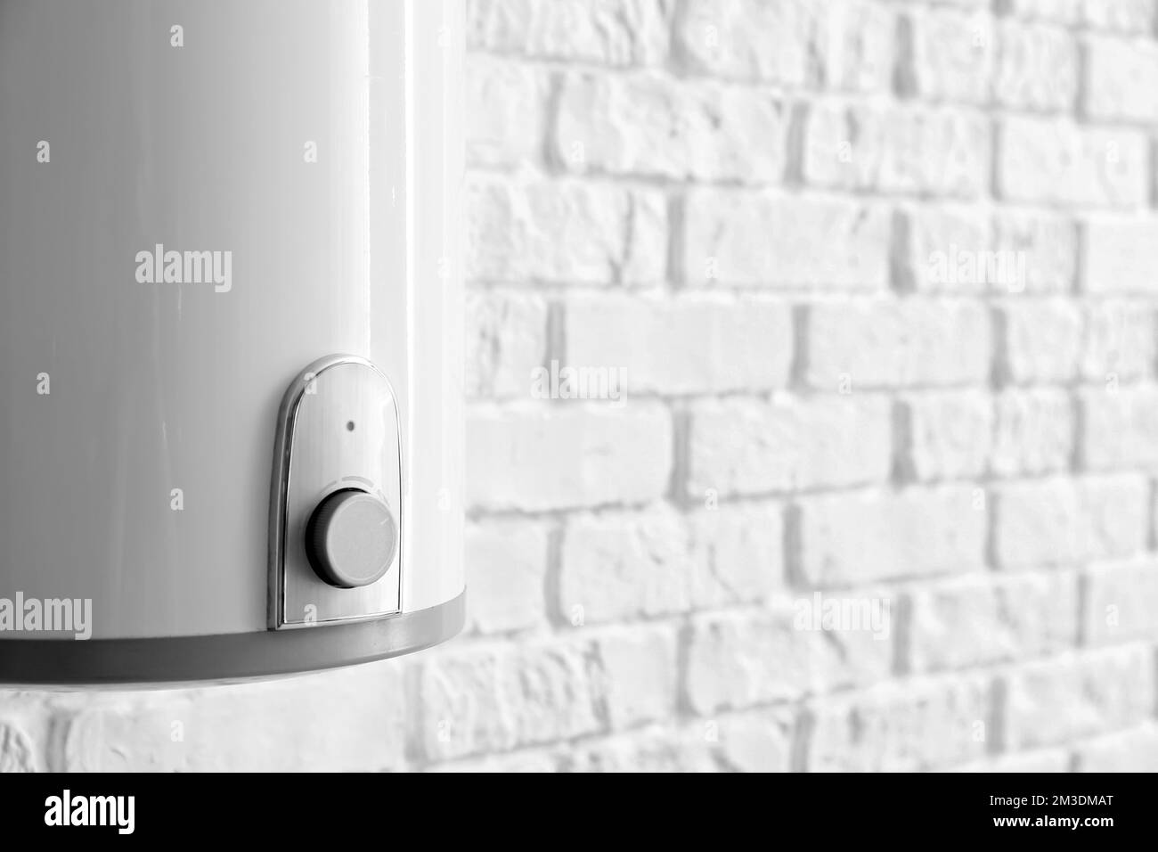Modern electric boiler on white brick wall, closeup Stock Photo - Alamy