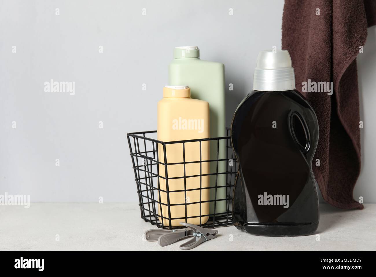 Laundry detergents and towel on table against grey background Stock ...
