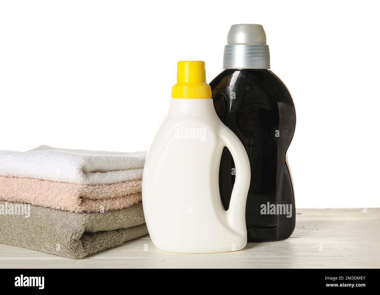 Laundry detergents and towels on table against white background Stock ...