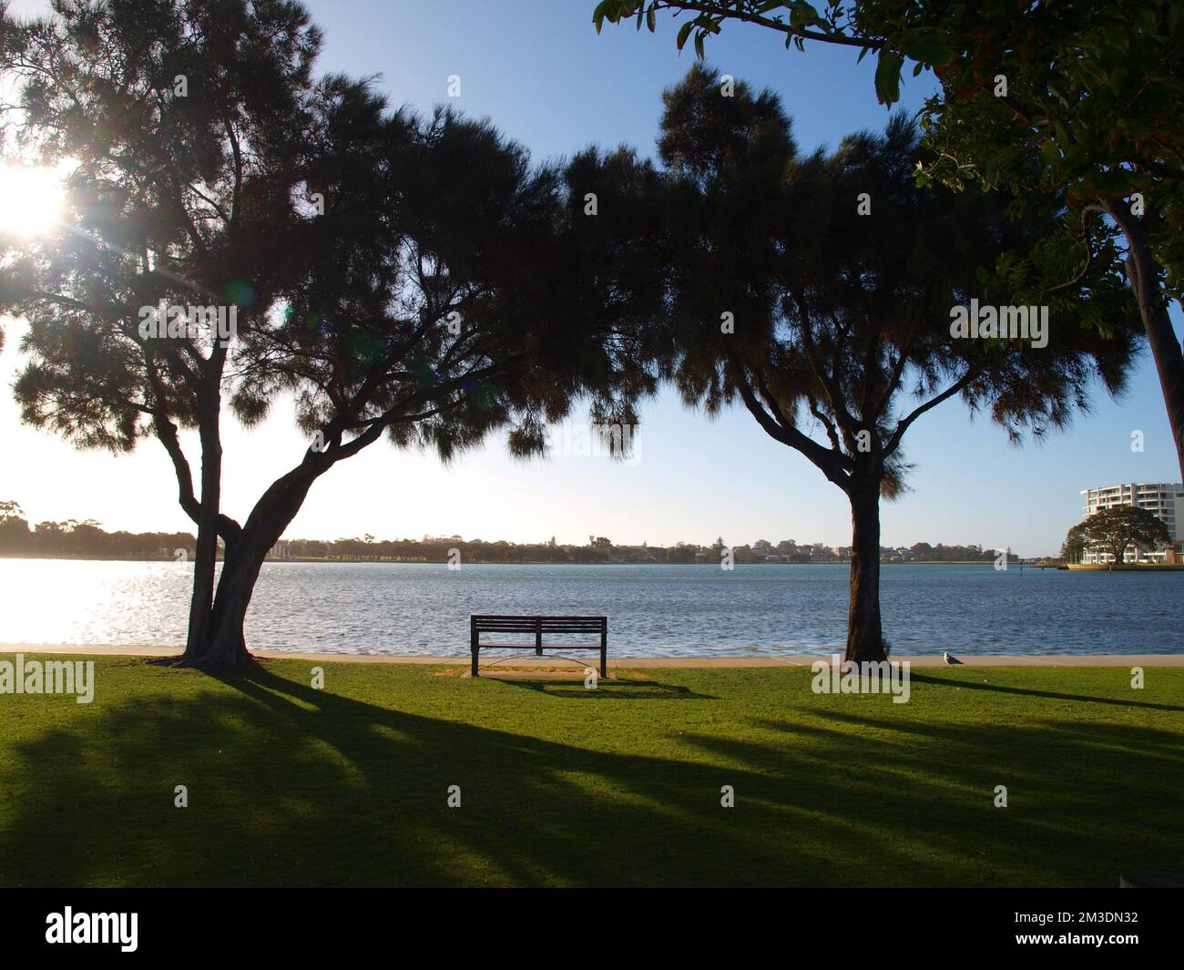Chair facing the waters of a lake at sunset in Mandurah, Australia ...