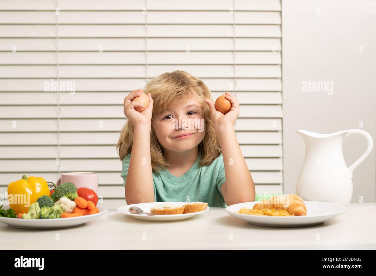 Kid eating egg. Portrait of child eat fresh healthy food in kitchen at ...