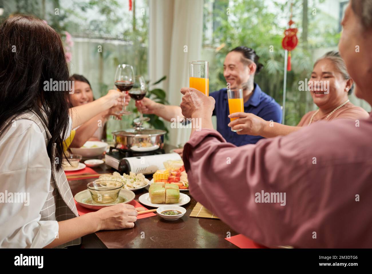 Family toasting at dinner table when celebrating Tet together Stock ...