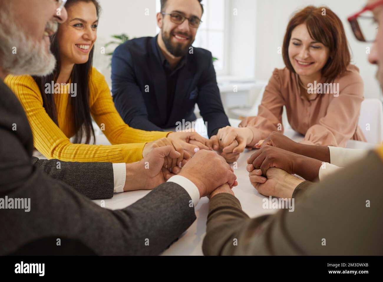 Team of happy supportive business people sitting together at office ...
