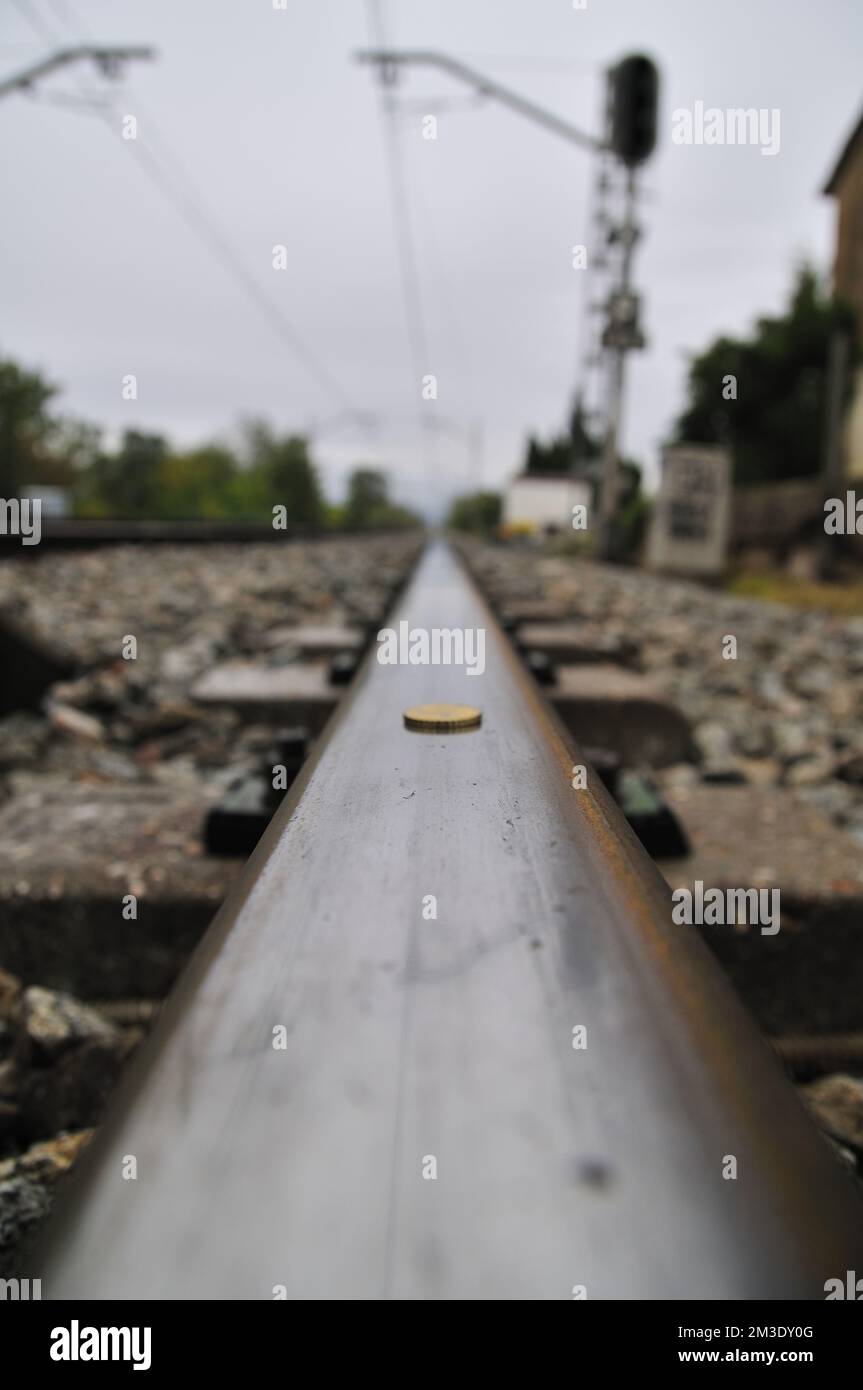 The vertical view of a golden coin on the rail of a railway Stock Photo ...