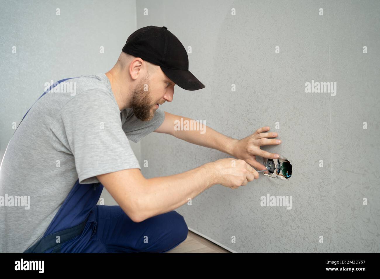 Electrician working safely on switches and sockets of household ...