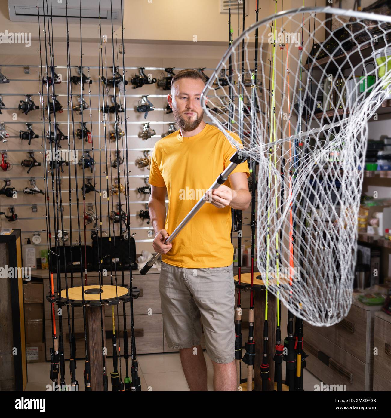 Man chooses a landing net in the sports shop. Copy space Stock Photo ...