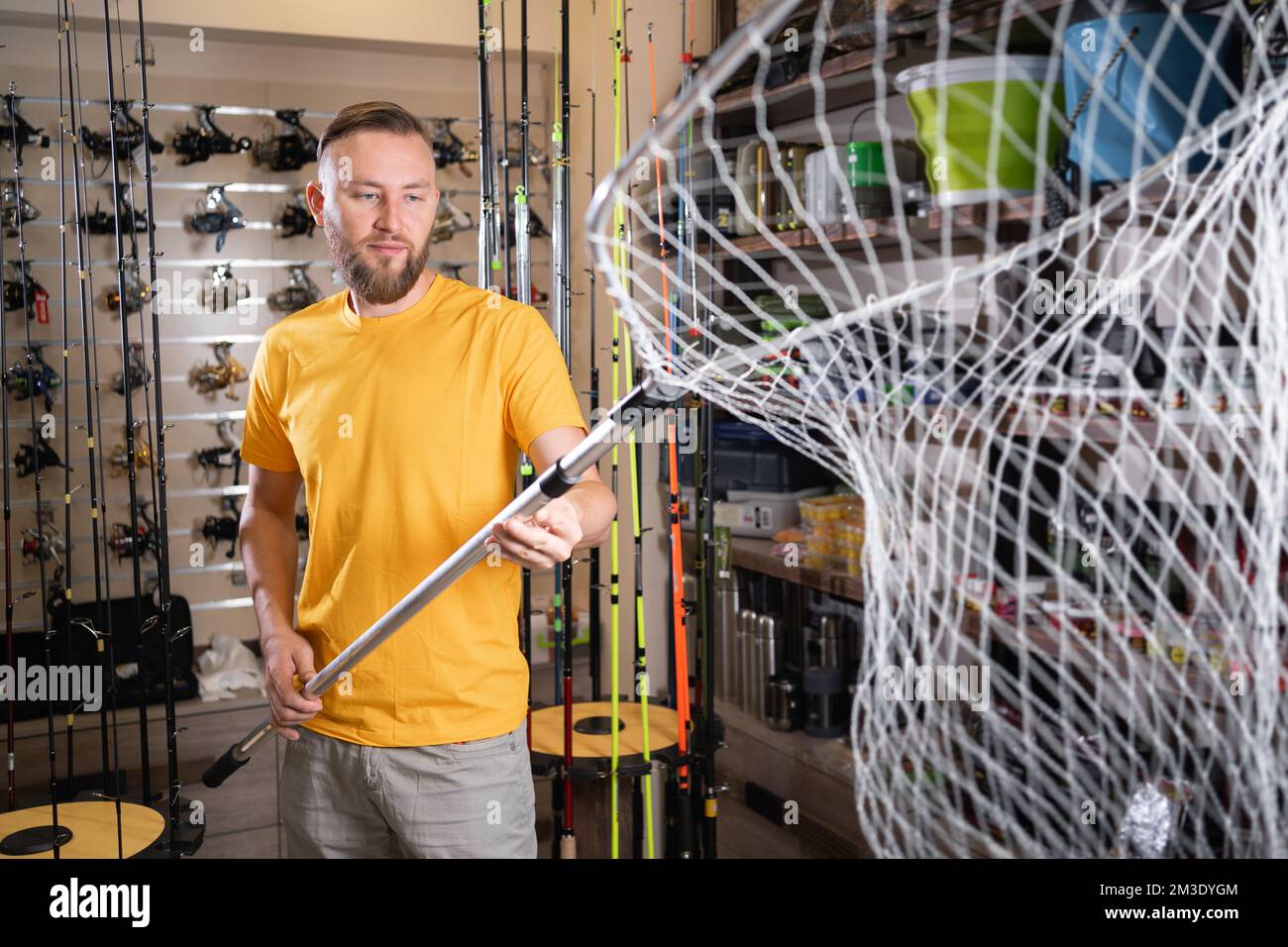 Fisherman choosing a landing net in a fishing shop. Copy space Stock ...