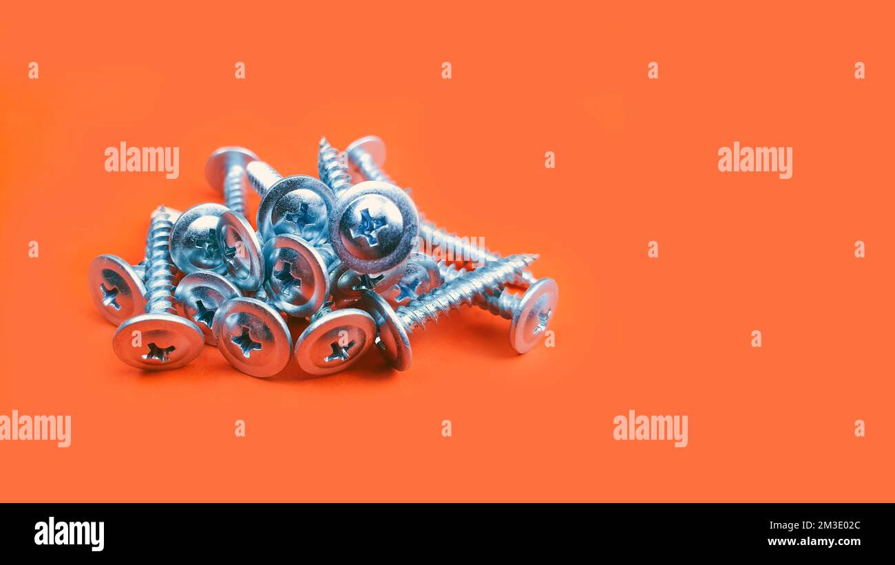 screws a lot, macro photo. Long Iron or metal screw nails on red ...