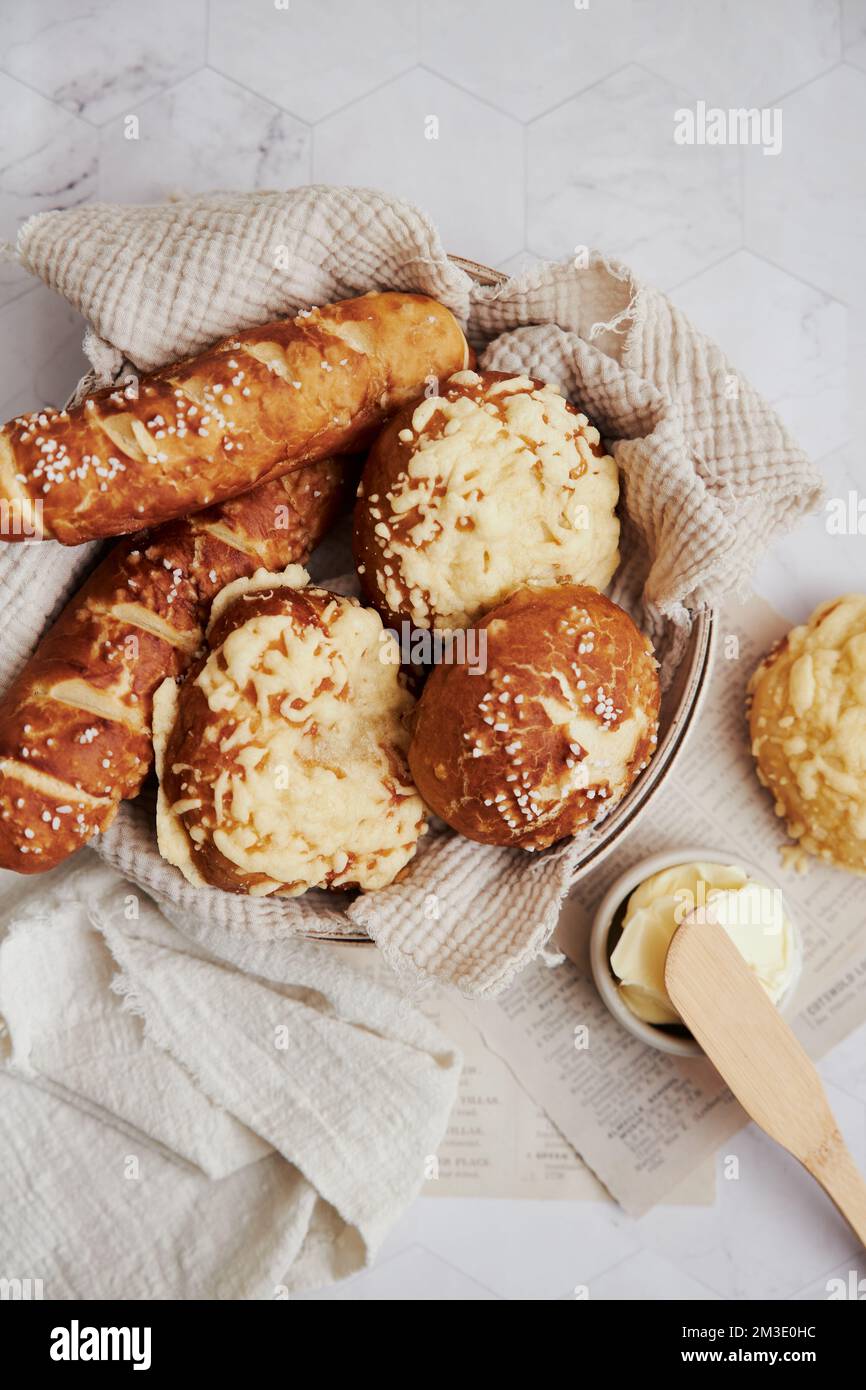 A closeup of delicious Laugen buns with salt and butter on a white ...