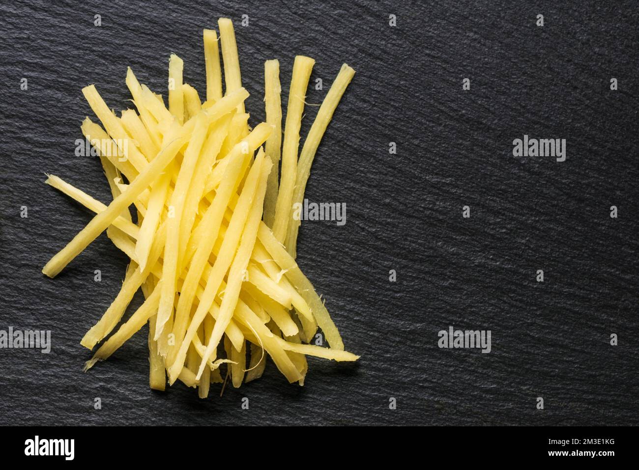 top view of pile vegetables roots of ginger chopped stripes on black ...