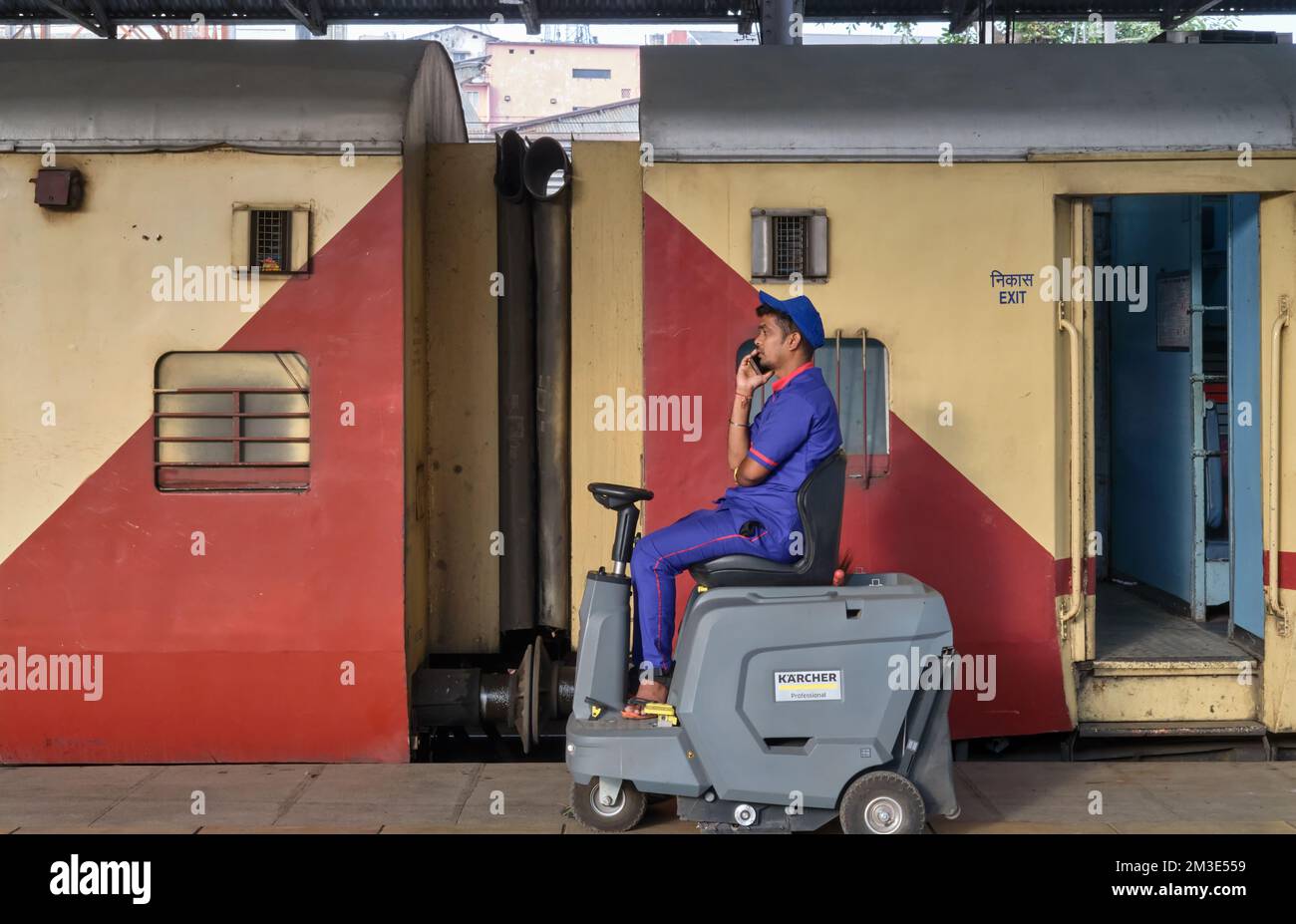 An cleaner sitting on a cleaning machine talking on his mobile; at ...