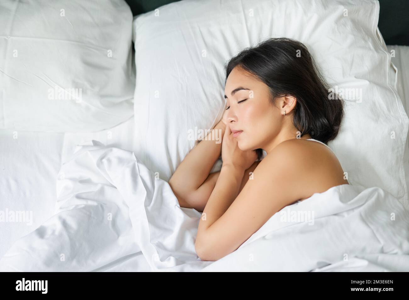 Top view image of asian woman sleeping alone in king size bed on white ...