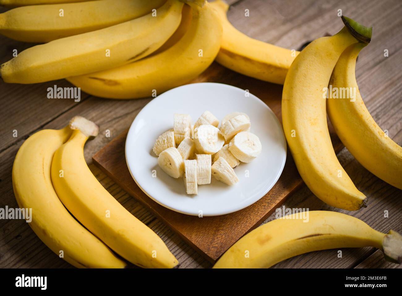 bunch of bananas - banana sliced on wooden background, ripe banana peel ...