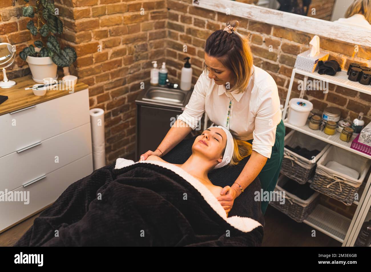 cosmetologist preparing a client for procedure at the sp center ...