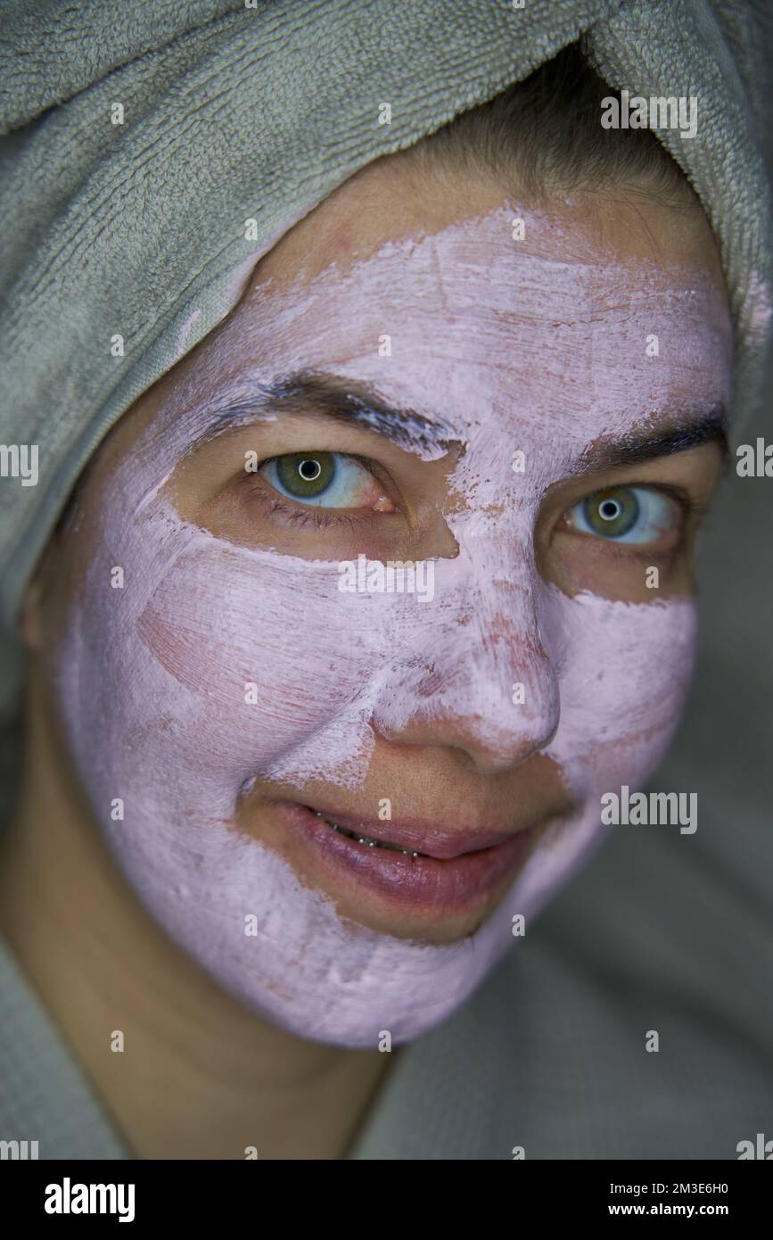 Woman with a towel over your head with face mask of therapeutic clay ...