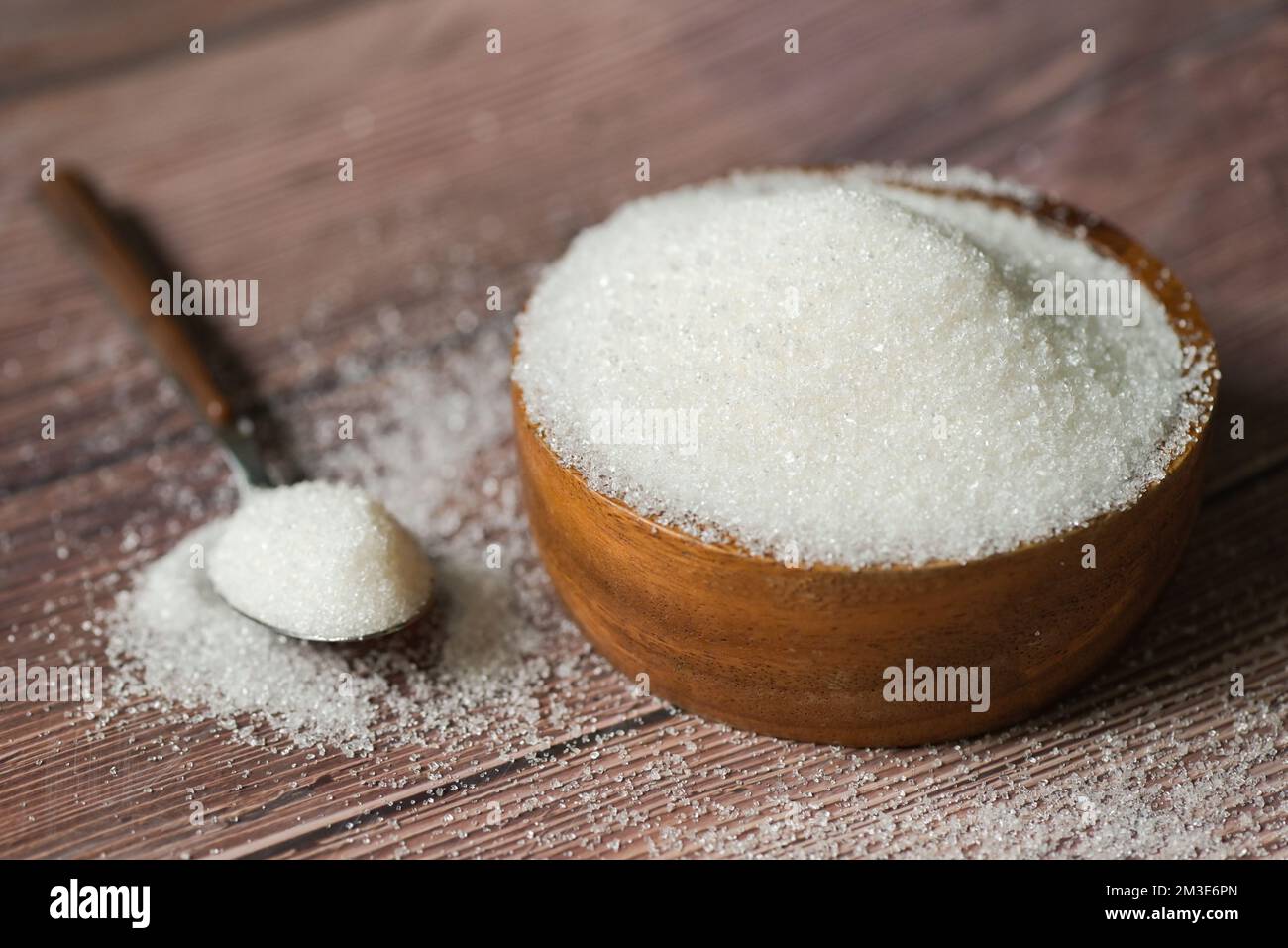 Sugar on spoon and wooden bowl, white sugar for food and sweets dessert ...
